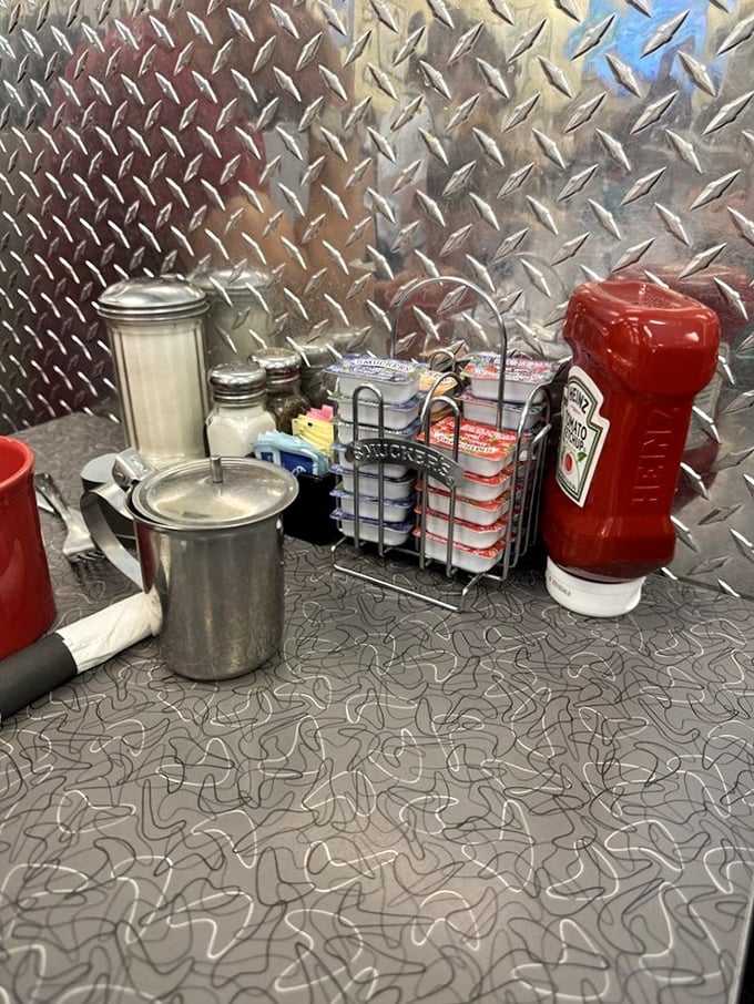 The diner tabletop essentials: sugar packets, ketchup, and salt and pepper shakers that have witnessed countless breakfast debates and coffee refills.