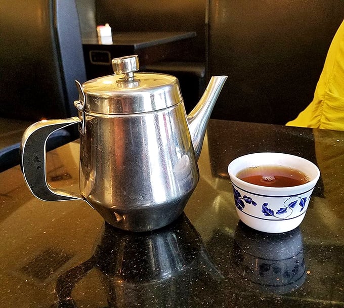 The humble teapot ritual – where every great Chinese feast begins and ends. This stainless steel pot delivers liquid comfort alongside a delicate blue and white cup of fragrant tea.