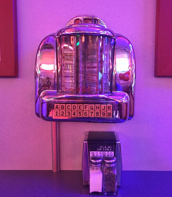 The vintage Seeburg wallbox—where once upon a time, two quarters could cure heartbreak with Patsy Cline or celebrate young love with Elvis. Today, it stands as a chrome-plated time capsule. 