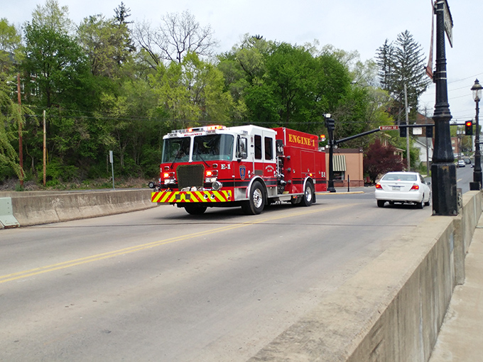 A fire engine crosses Bellefonte's bridge, a splash of emergency red against the town's genteel historic backdrop.