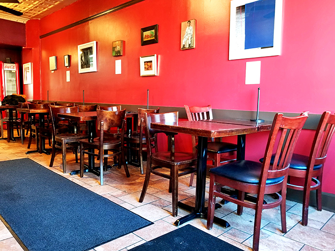 Simple tables, red walls, and framed art create the perfect backdrop for the real masterpieces that arrive on your tray.
