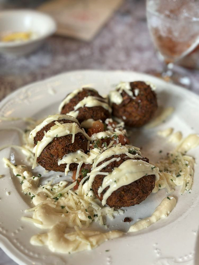These aren't your average fritters. Golden-brown perfection topped with cheese that stretches with each bite—resistance is futile.