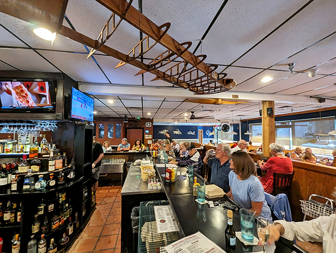 The bar area where regulars exchange fishing stories and food recommendations. That wooden boat hanging from the ceiling isn't just decor—it's foreshadowing.