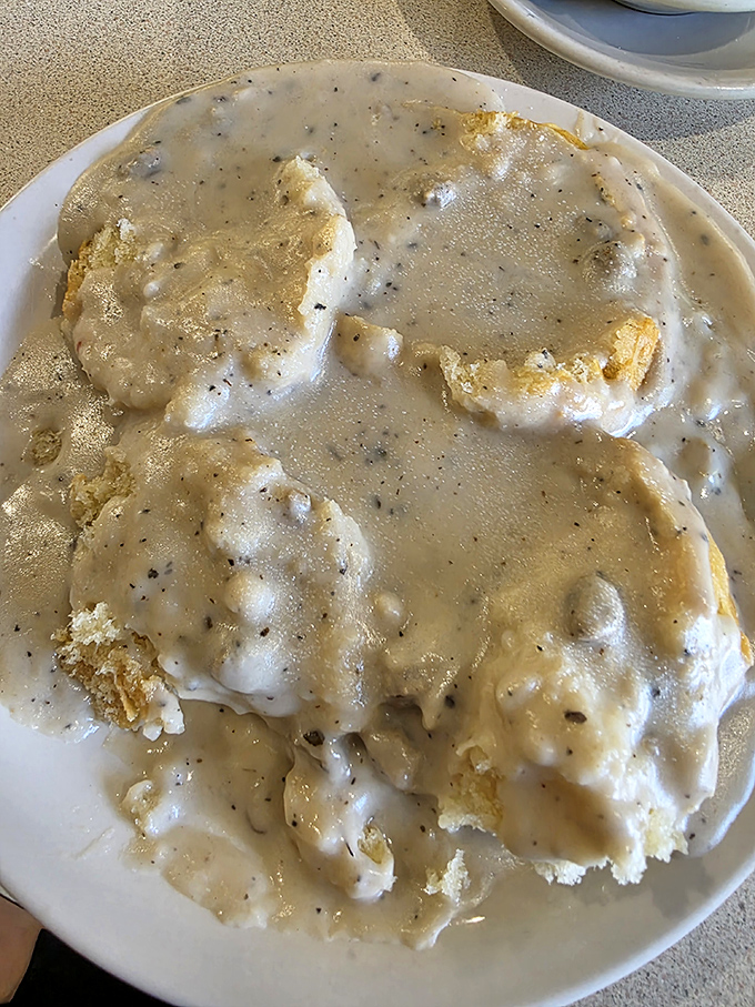 Biscuits and gravy that could make a southern grandmother nod in approval—peppery cream gravy blanketing pillowy islands of fresh-baked comfort.
