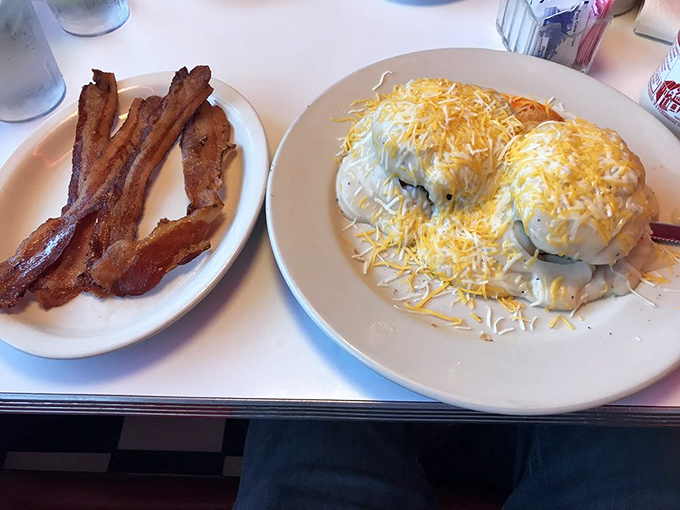 Biscuits blanketed in creamy gravy alongside bacon strips that achieved the perfect balance between crisp and chewy—breakfast nirvana achieved.