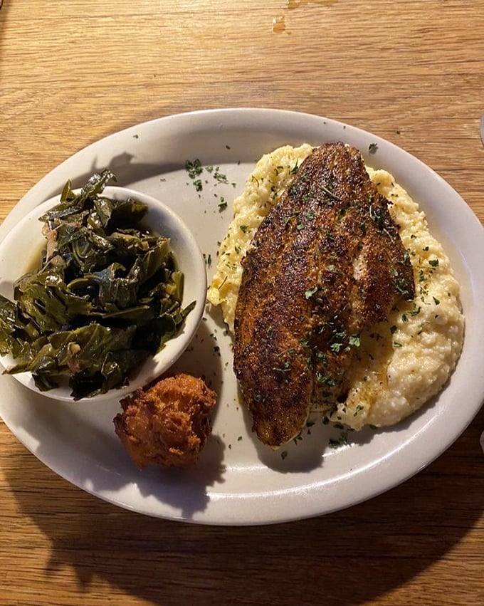 Blackened catfish resting on a cloud of cheese grits with collards on the side—Southern comfort that hugs you from the inside out.