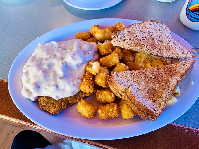 The legendary Bronco Buster plate—where country-fried goodness meets creamy gravy and crispy tater tots in perfect harmony.