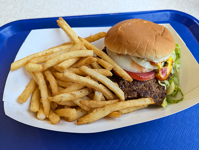 The platonic ideal of an American lunch—a burger that requires both hands and napkins, with fries so perfect they deserve their own fan club.