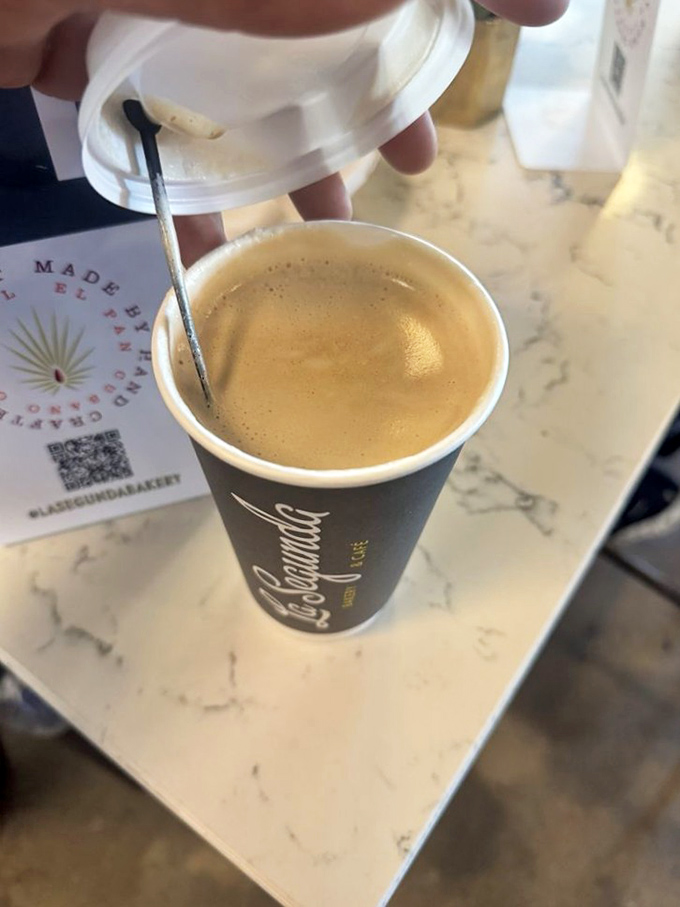 Café con leche—where coffee meets milk in a dance so perfect it deserves its own Broadway show. The spoon stands by, ready for its stirring solo.