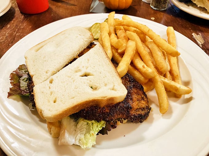 This sandwich doesn't just sit on the plate—it commands attention with its substantial presence and golden-crusted bread flanked by perfectly crisp fries.