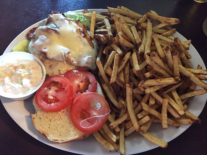 This sandwich practically demands a two-handed commitment. Crispy fries standing at attention beside melty cheese cascading over perfectly cooked protein—a plate of pure satisfaction.