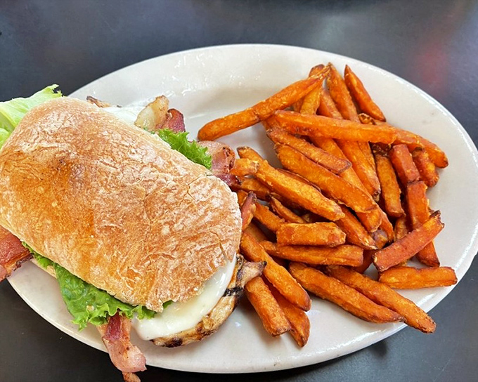 A sandwich that understands the importance of balance—crispy bacon, fresh veggies, and sweet potato fries for a touch of the unexpected. 