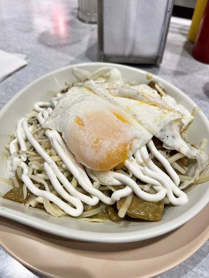 Chilaquiles topped with a sunny-side-up egg and zigzags of sauce—breakfast with attitude that wakes up your taste buds and your spirit.