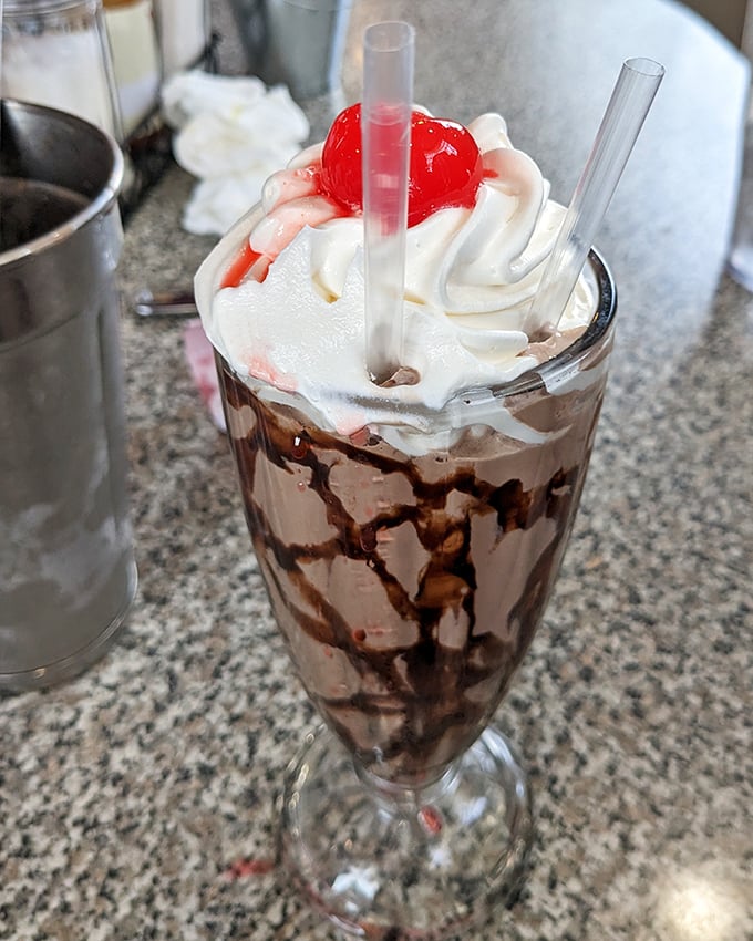 This chocolate malt isn't just a drink, it's a tower of childhood memories topped with whipped cream and that essential cherry crown.