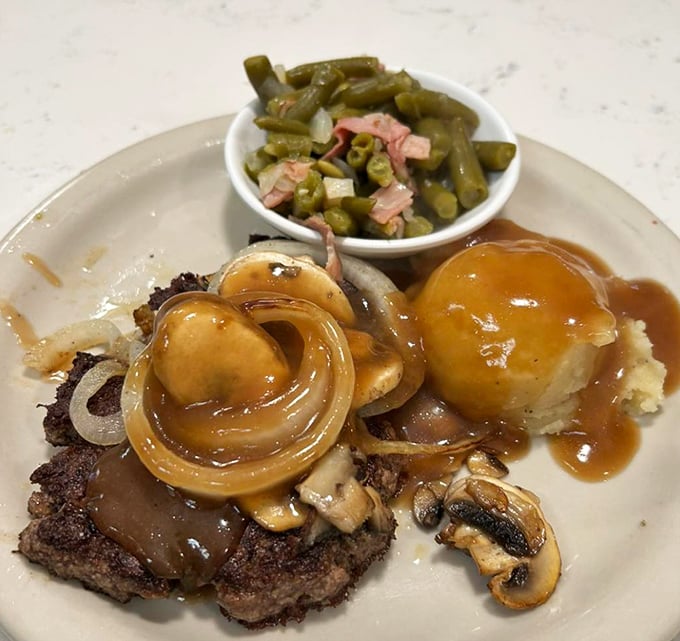 A plate of chopped sirloin smothered in gravy and onions with a side of green beans – comfort food that speaks directly to your soul.