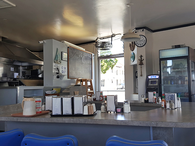Classic diner efficiency on display—napkin dispensers, sugar caddies, and menus all within arm's reach while you contemplate your next coffee refill.
