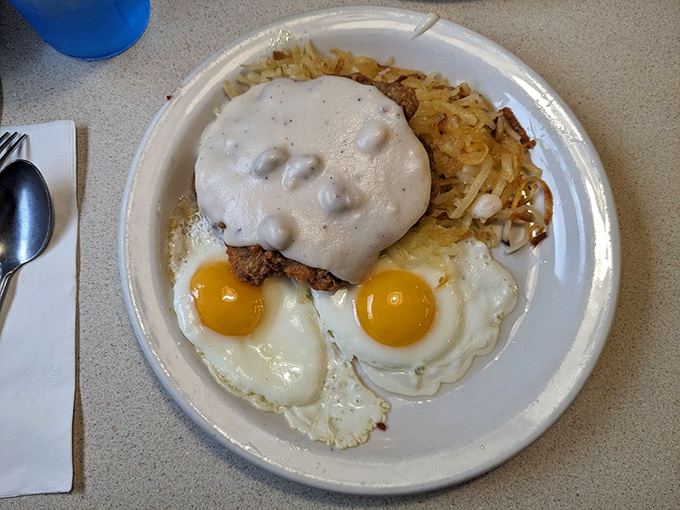 Country fried steak crowned with gravy, flanked by sunny-side-up eggs—a plate that says "You won't need dinner tonight."