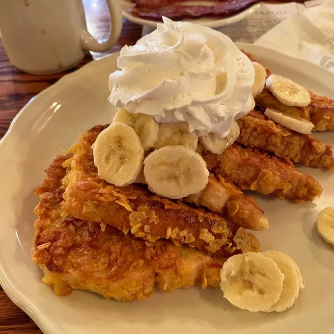 Cornflake-crusted French toast with bananas and whipped cream—the breakfast equivalent of wearing a tuxedo to a pool party.