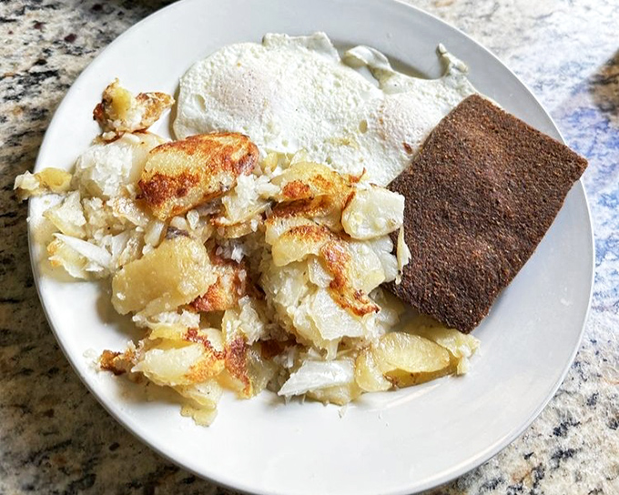 The perfect breakfast trinity: crispy home fries, eggs cooked just right, and scrapple—Pennsylvania's contribution to morning happiness.