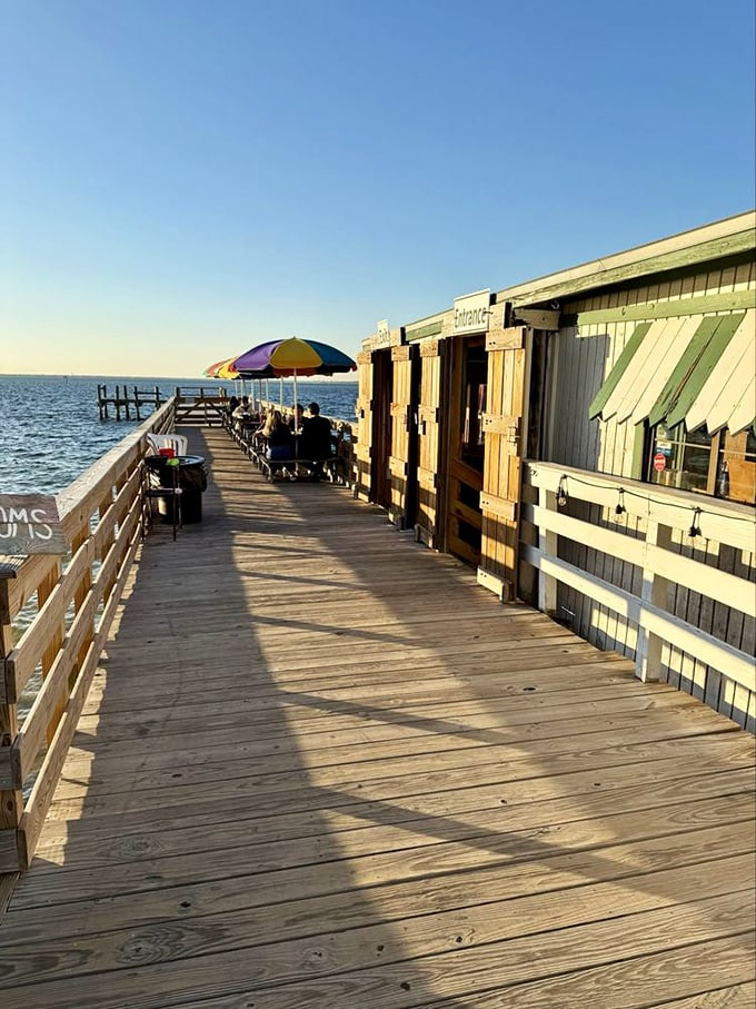 A wooden walkway to seafood nirvana – where rainbow umbrellas and harbor views set the stage for memorable meals.