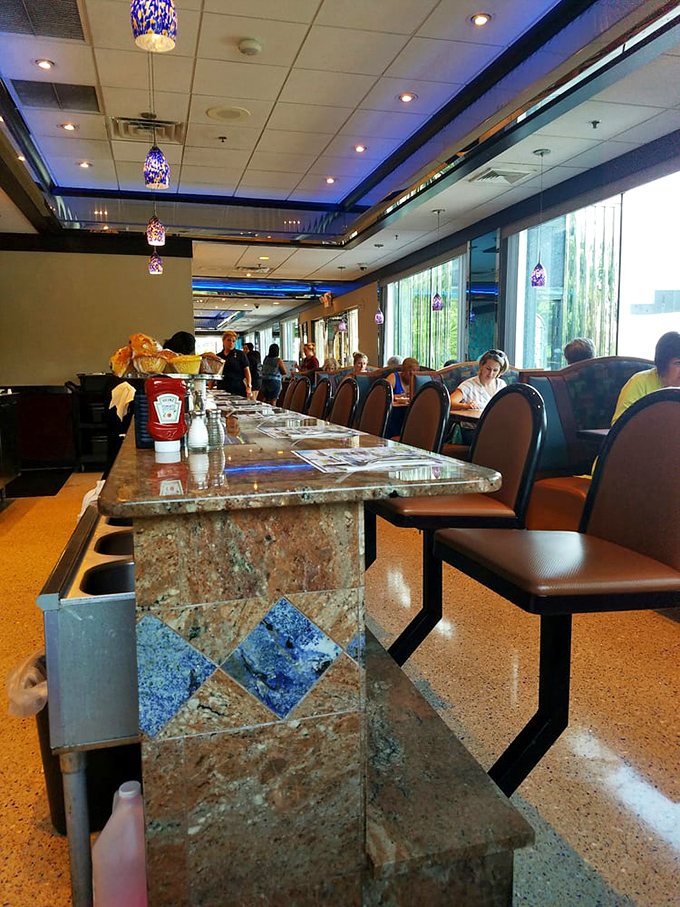 Blue pendant lights cast a gentle glow over diners enjoying the timeless ritual of breaking bread together.