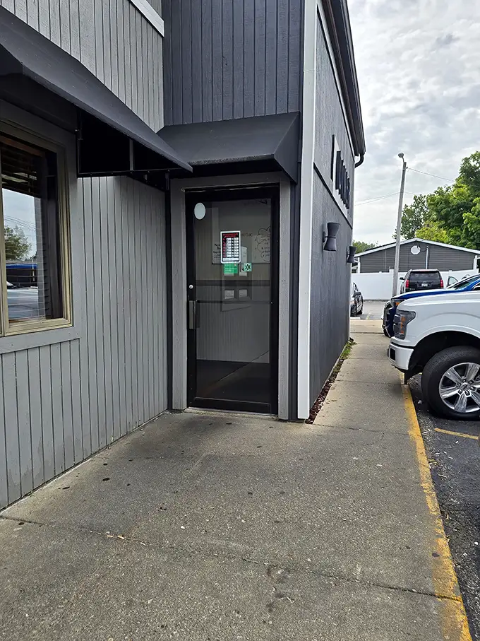 The side entrance—where regulars slip in for their usual without fanfare. That door has welcomed more hungry souls than most therapists.
