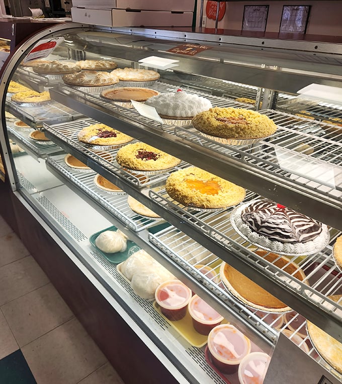 This display case isn't merely showing pies; it's exhibiting edible art that happens to taste even better than it looks.