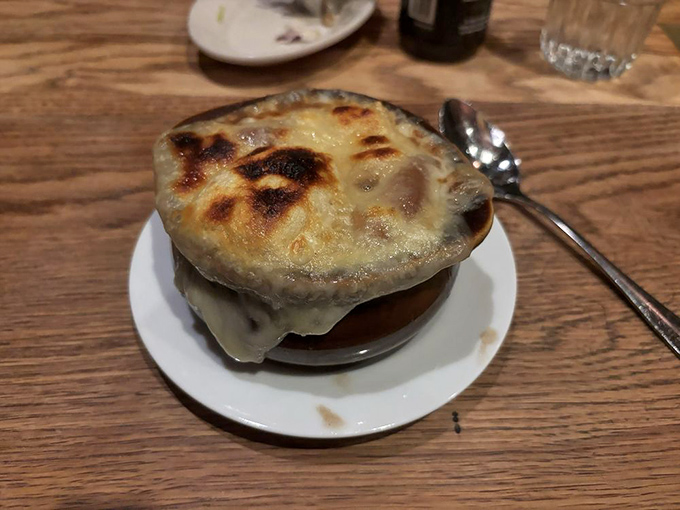 This isn't just French onion soup—it's a cheese-crowned masterpiece with a broth so rich it could buy real estate in Beverly Hills.