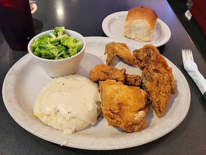 Fried chicken that crackles with each bite, mashed potatoes under a gravy waterfall, and broccoli pretending it's the star of the show.