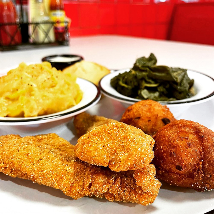 Golden-fried perfection meets Southern sides—crispy catfish alongside mac and cheese and collard greens creates the holy trinity of comfort food.