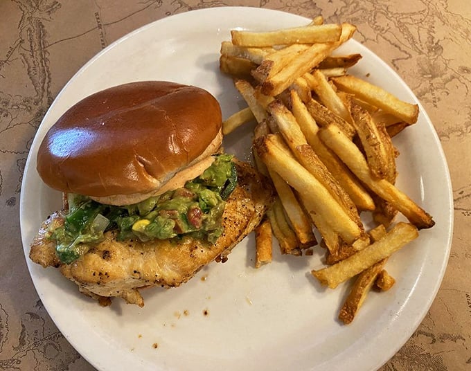 This chicken sandwich with its crown of avocado and fresh greens isn't just lunch—it's edible architecture that happens to taste amazing.