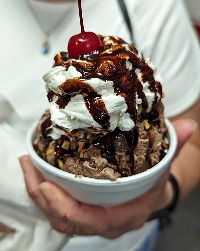Hot fudge cascading over cold ice cream—proof that opposites don't just attract, they create moments of pure bliss topped with a cherry.