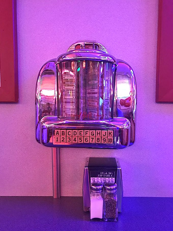 This tabletop jukebox isn't just decoration—it's a time machine offering three minutes of nostalgia for just a quarter, with salt and pepper standing by.
