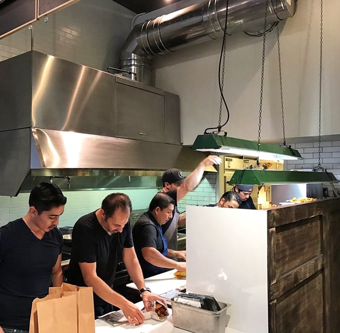 The kitchen crew in their element—culinary choreography in action. This is where the magic happens, one perfectly fried piece of chicken at a time.