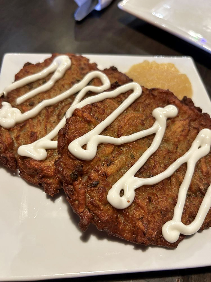 Crispy potato latkes drizzled with sour cream—golden discs of happiness that crackle with each delicious bite.