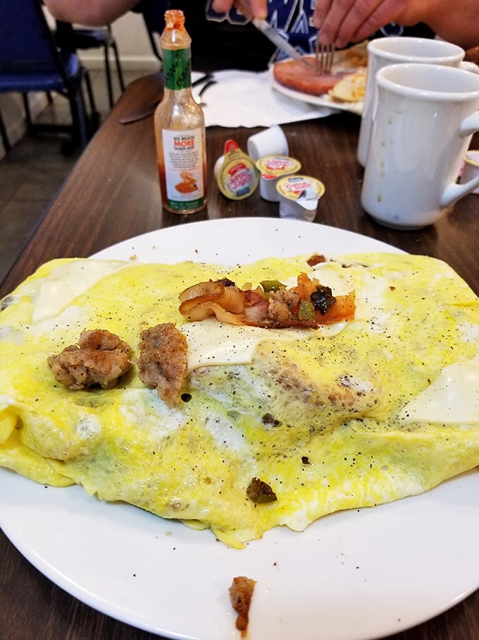 This omelet could feed a small family – stuffed with savory fillings and cooked to that elusive perfect doneness that home cooks dream about.
