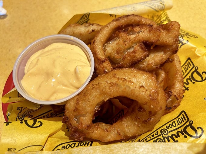 Crispy, golden onion rings with creamy sriracha sauce—because sometimes your hot dog needs a sidekick with a spicy attitude.