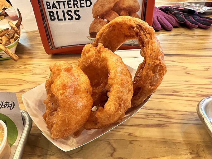 These aren't just onion rings – they're golden halos of happiness. Thick-cut, beer-battered, and fried to that perfect crunch that echoes when you bite.