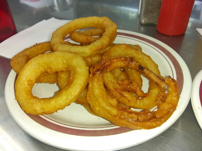 Onion rings that shatter like glass when bitten—the perfect crispy-to-onion ratio that chain restaurants have tried to replicate for decades.