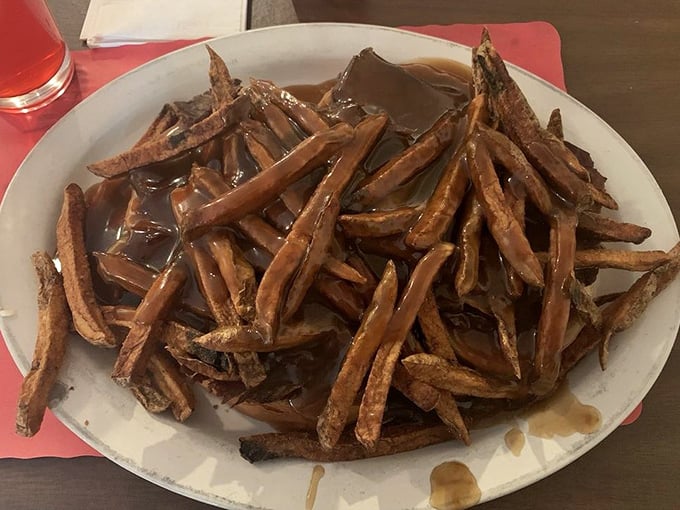 Gravy isn't just a condiment here; it's practically a beverage – these open-faced roast beef fries swim in a pool of savory goodness that demands bread for sopping. 