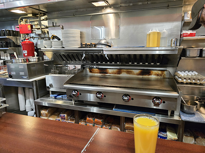 The battlefield where breakfast battles are won—a well-seasoned flat-top grill flanked by the tools of the trade and liquid sunshine waiting to be served.