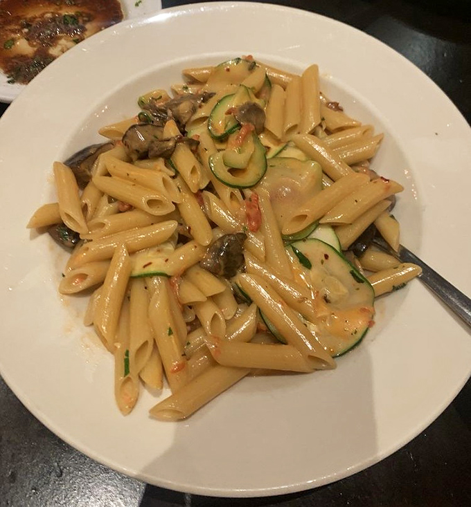 This penne isn't just pasta—it's a canvas where zucchini and mushrooms create edible art that happens to be utterly delicious.