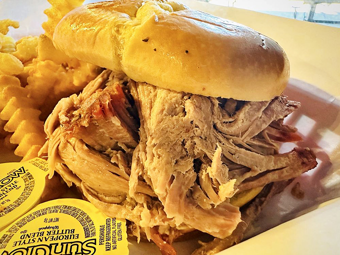 A proper pulled pork sandwich should require both hands and several napkins. This one passes the test with flying, sauce-stained colors.