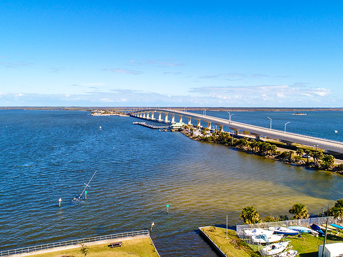 The causeway stretches across the blue expanse like a lifeline between worlds – Titusville on one side, natural Florida treasures on the other.