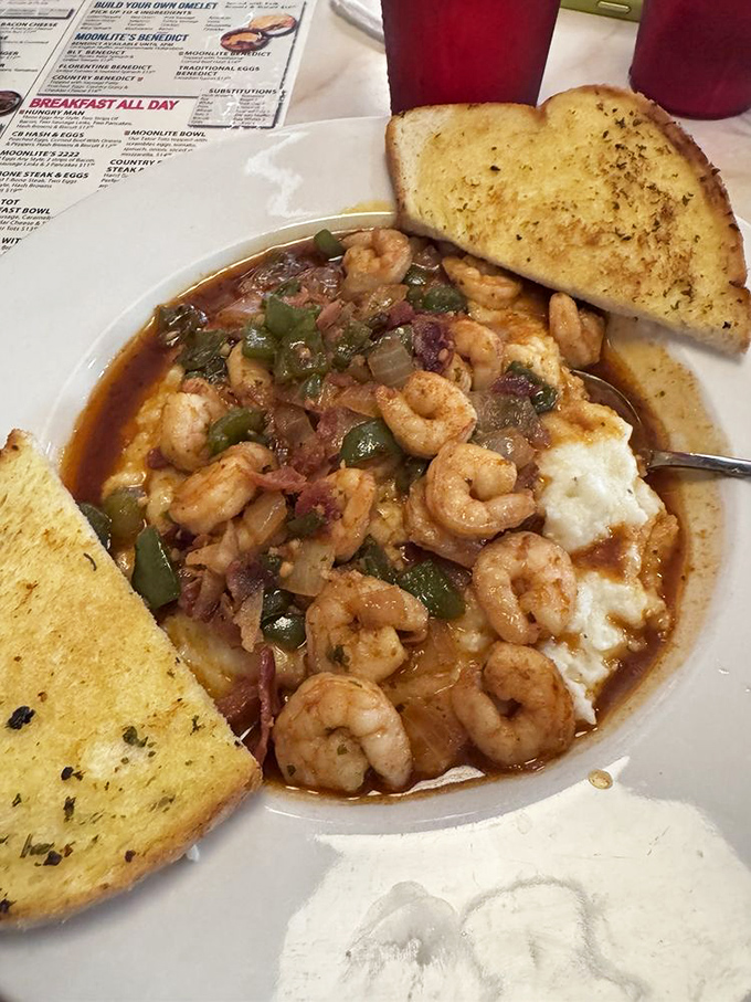 Shrimp and grits with a Florida twist—plump crustaceans swimming in savory broth alongside garlic toast perfect for sopping up every last drop.