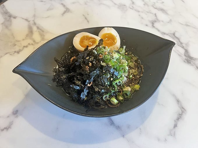 Black garlic oil transforms these noodles into edible art – mysterious, dramatic, and absolutely delicious.
