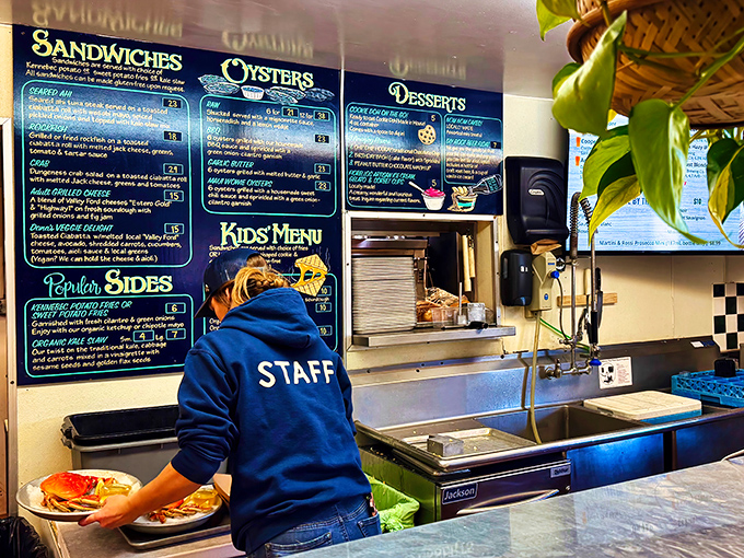 Where the magic happens—a staff member navigating the kitchen dance that transforms fresh catches into memorable meals for eager diners.