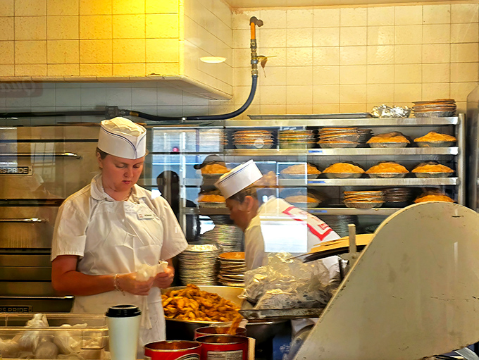White uniforms and paper hats—the timeless uniform of burger artisans who've mastered their craft through decades of practice.
