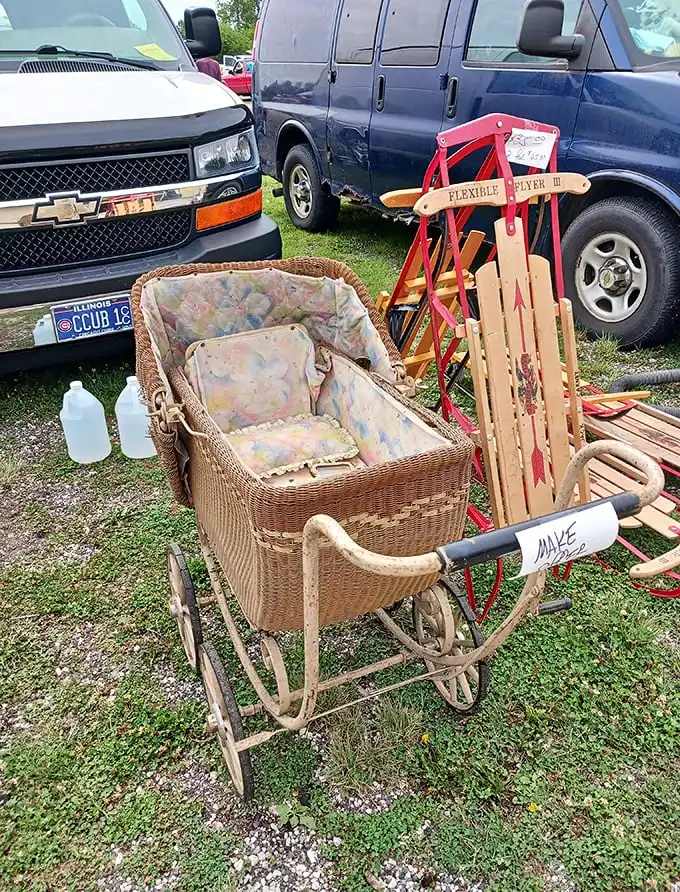 A wicker baby carriage from yesteryear sits beside a vintage Flexible Flyer sled—childhood nostalgia with a Cubs license plate bonus.