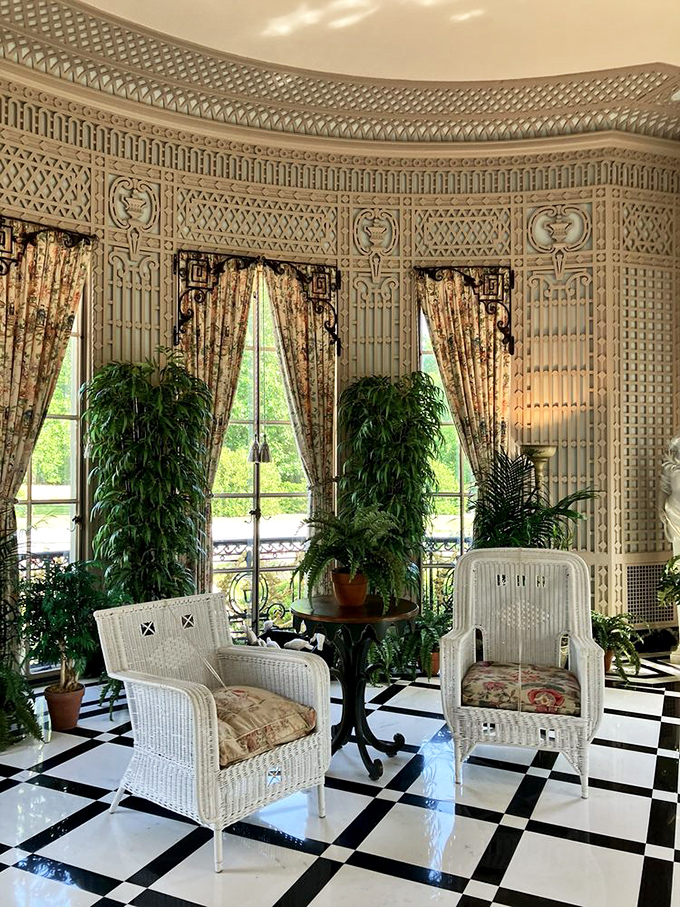 The conservatory where plants live better than most humans. Those wicker chairs have witnessed countless afternoon teas.